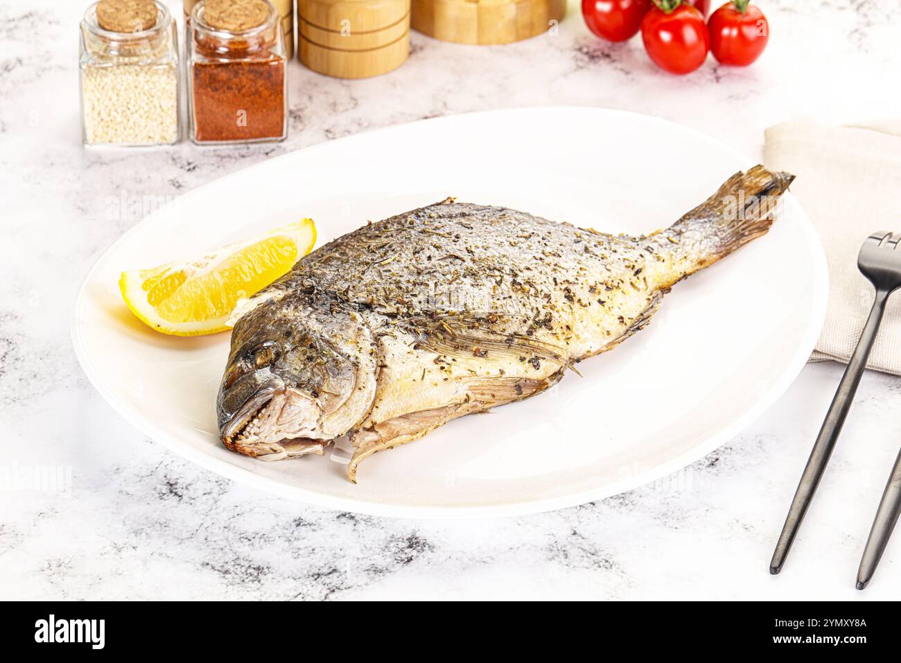 Baked Dorado fish served lemon slice Stock Photo - Alamy