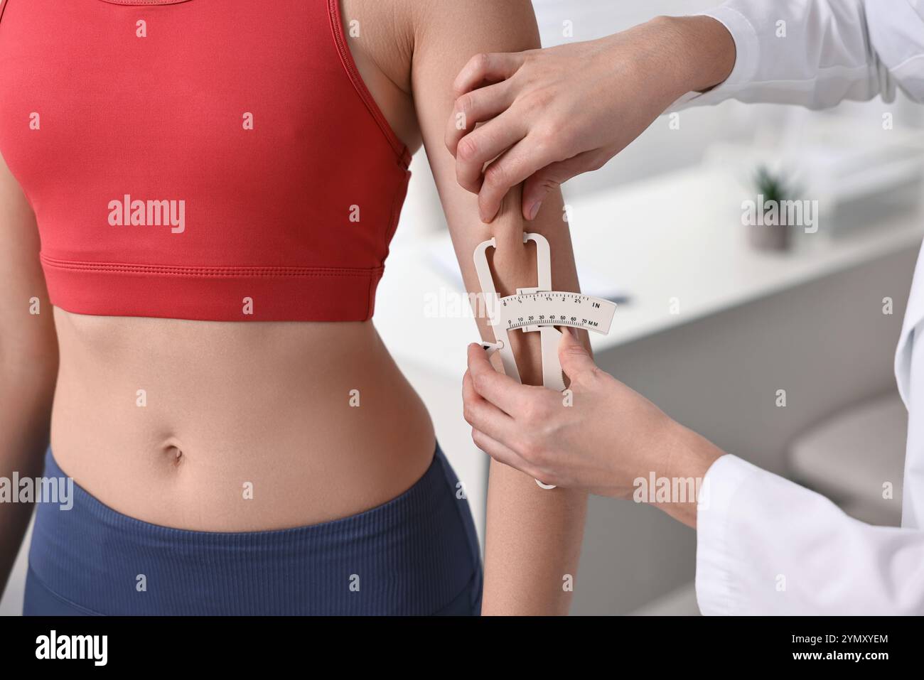 Doctor measuring woman's body fat with caliper in clinic, closeup Stock ...