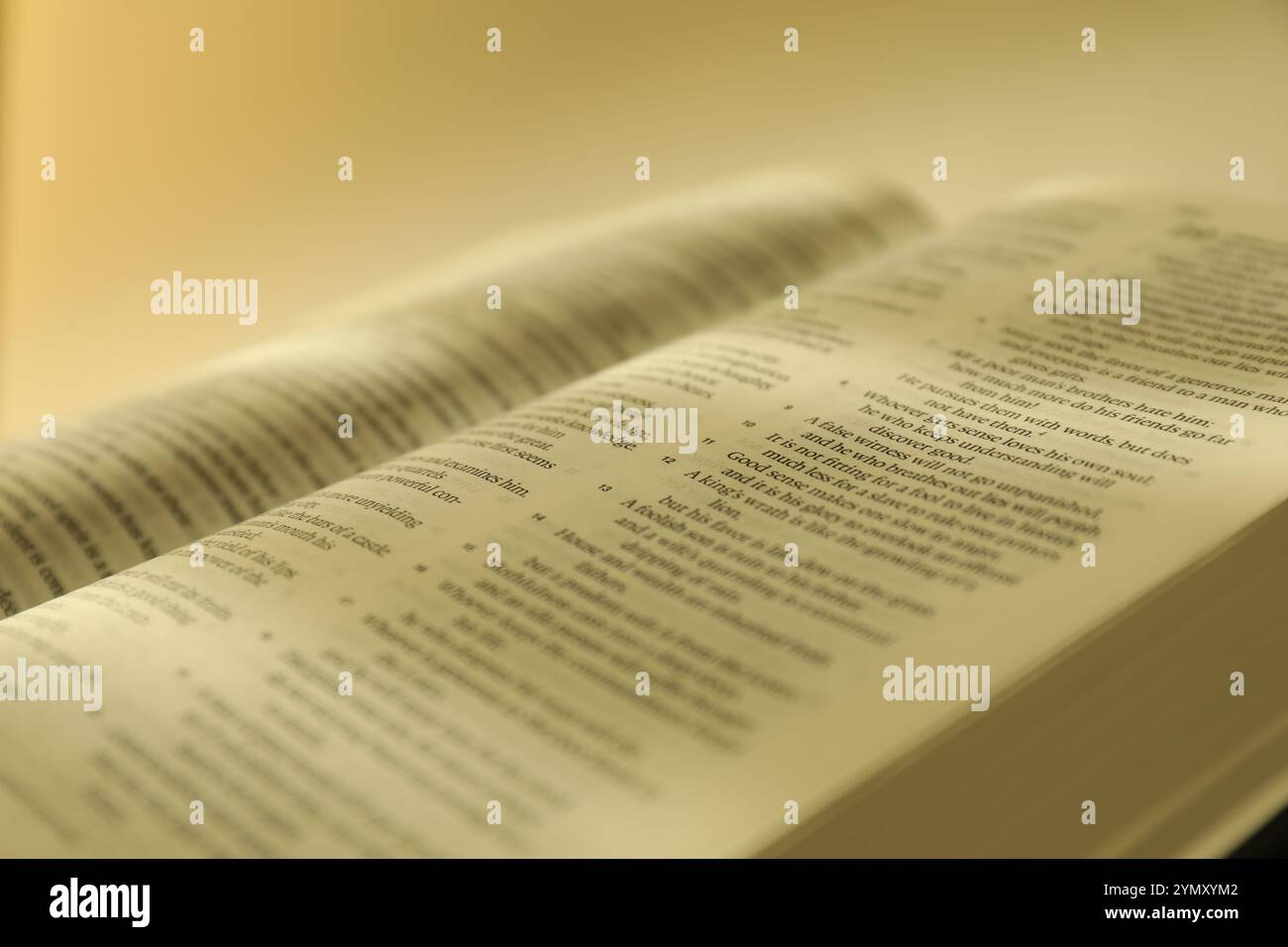 Open Holy Bible in English language against beige background, closeup ...