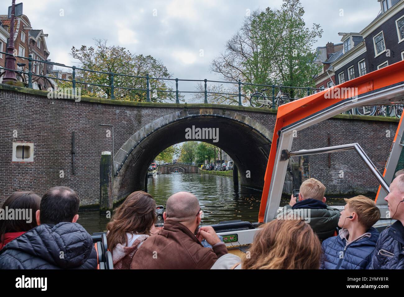 Tourists on a guided canal tour of historical centre of Amsterdam ...