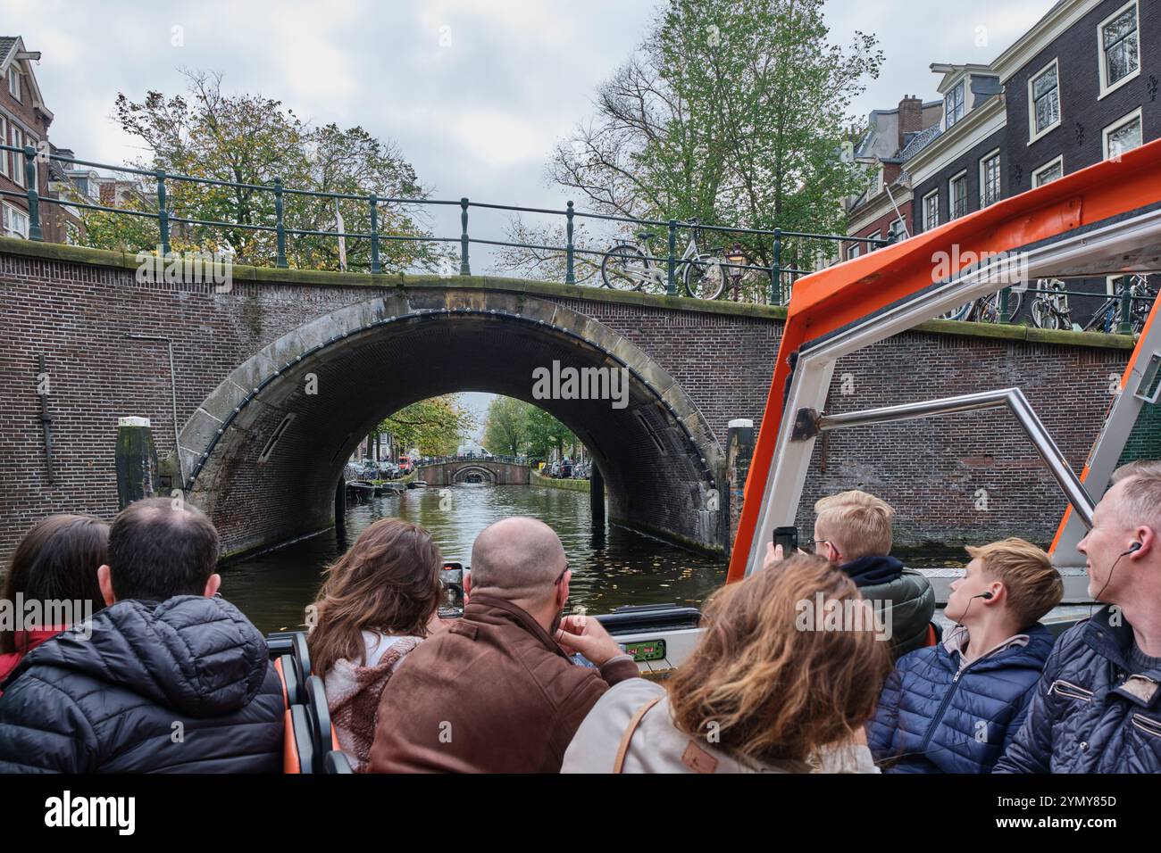Tourists on a guided canal tour of historical centre of Amsterdam ...