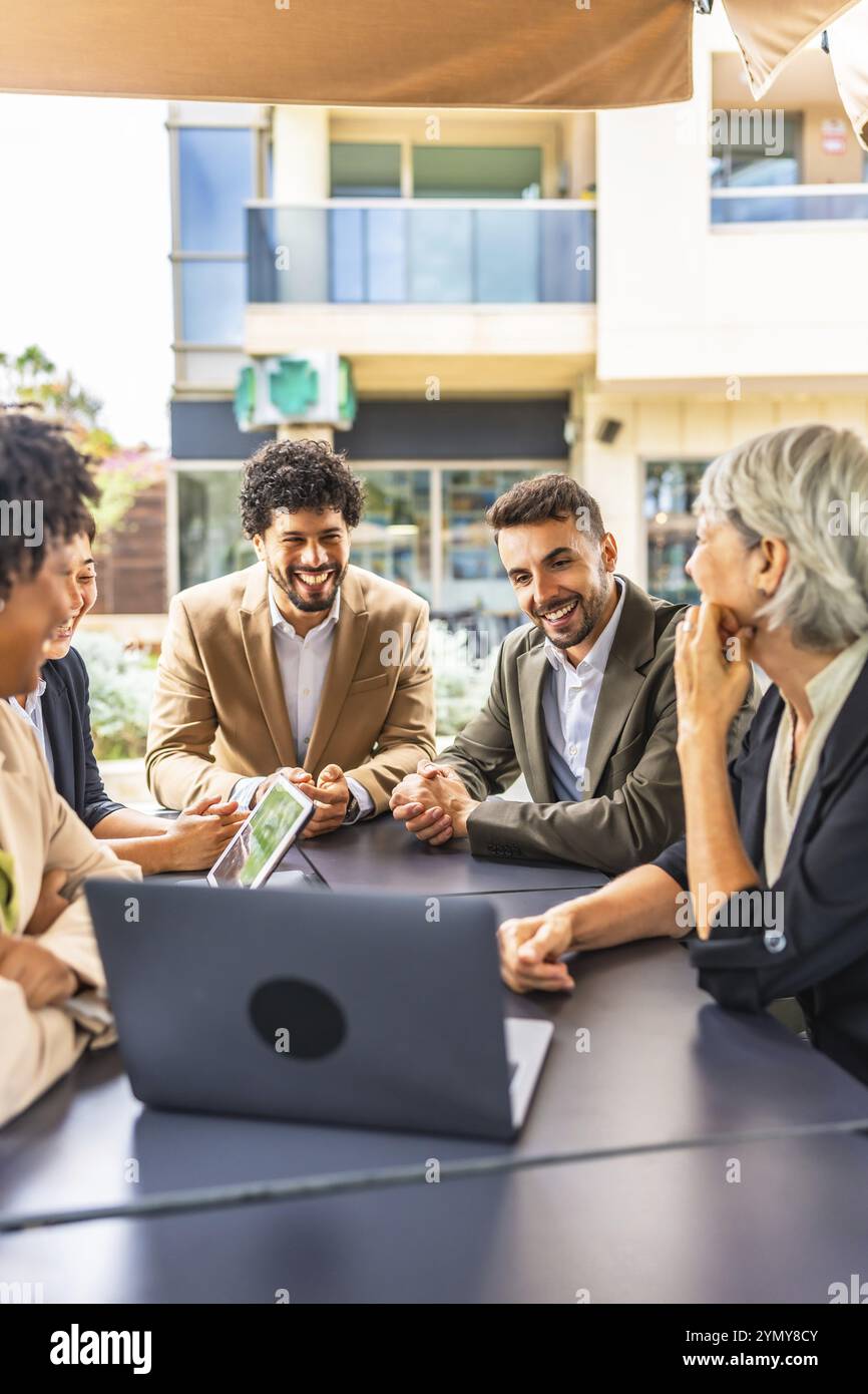 Vertical photo of a group of diverse business people using laptop ...