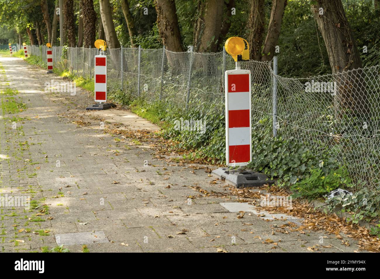Walkway with wire fence and warning beacons Stock Photo - Alamy