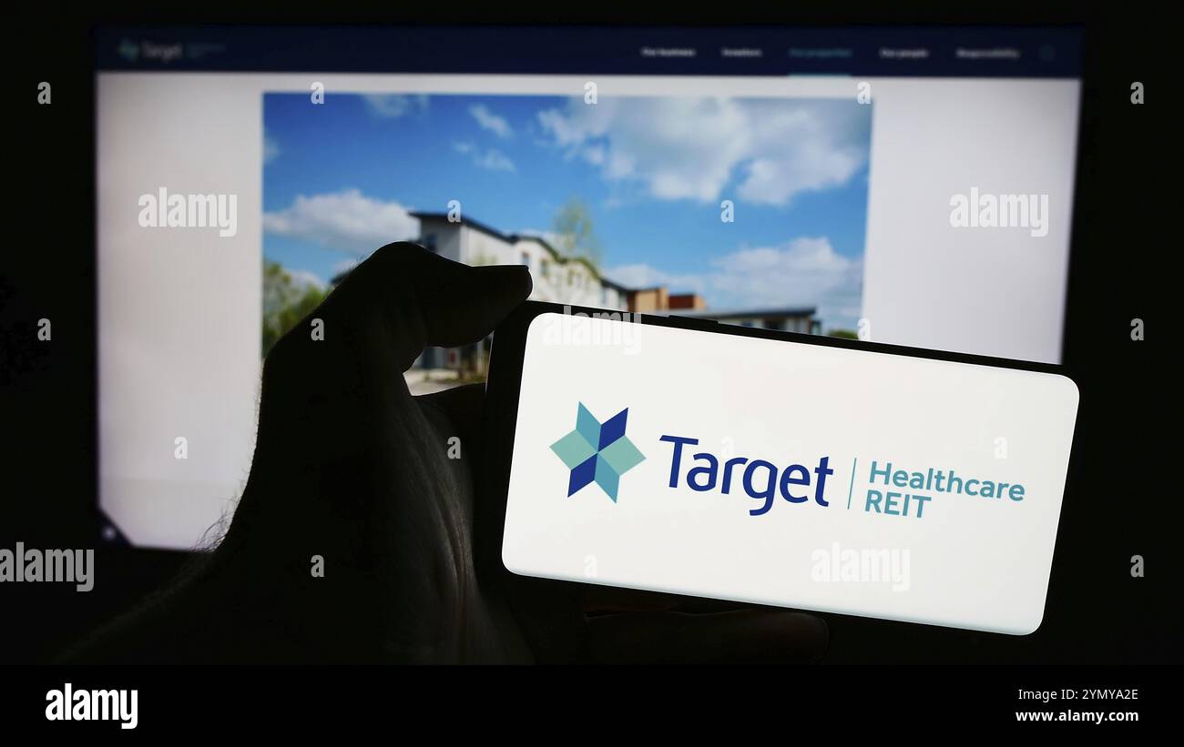Stuttgart, Germany, 05-29-2024: Person holding cellphone with logo of British property company ...