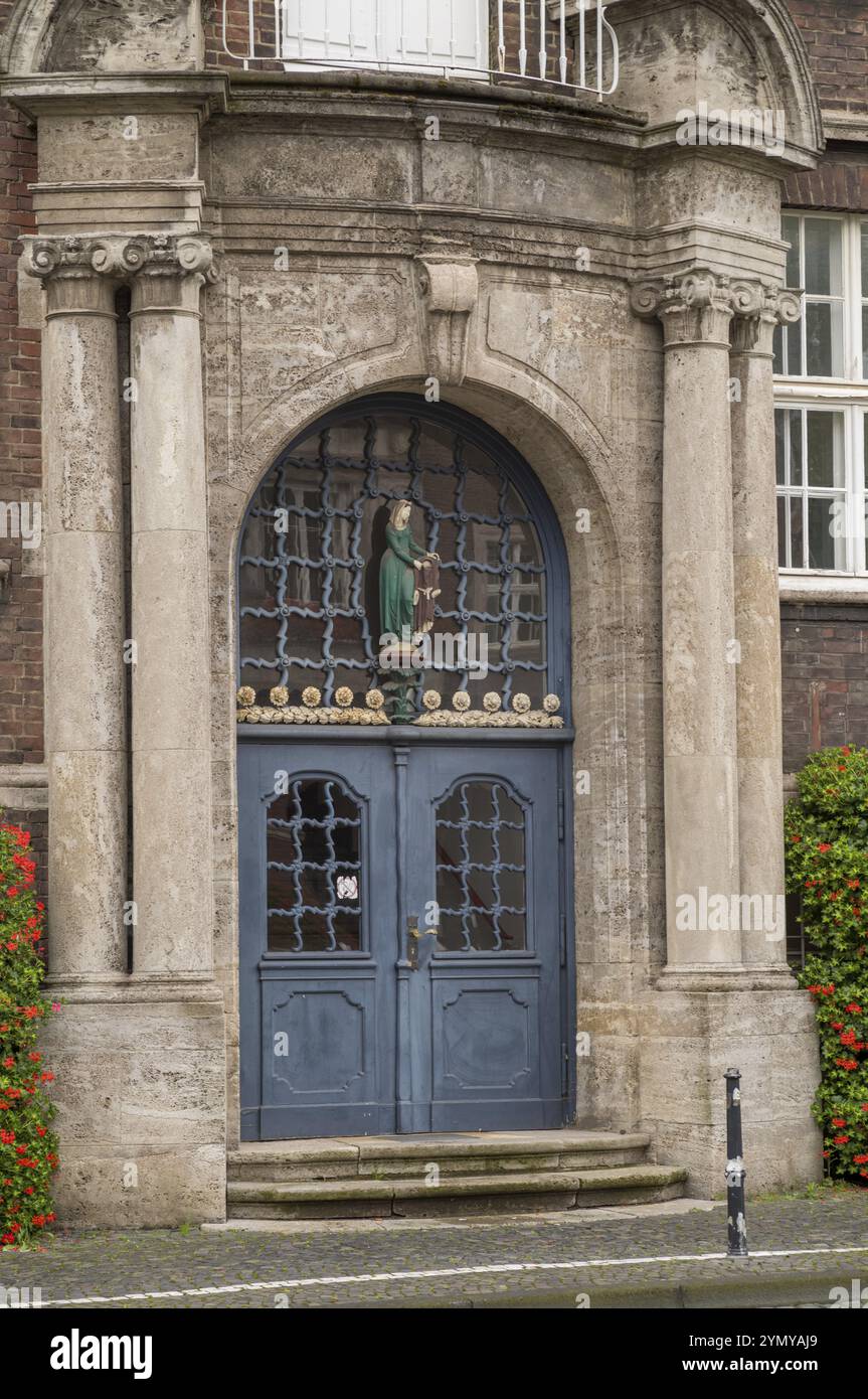 Large door with figure on a 100 year old building Stock Photo - Alamy