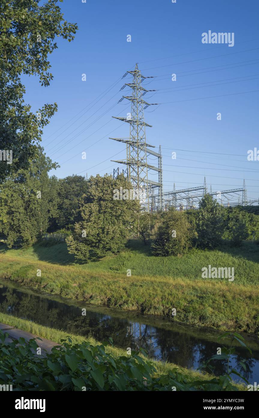 High-voltage pylons with sewer in the countryside Stock Photo - Alamy