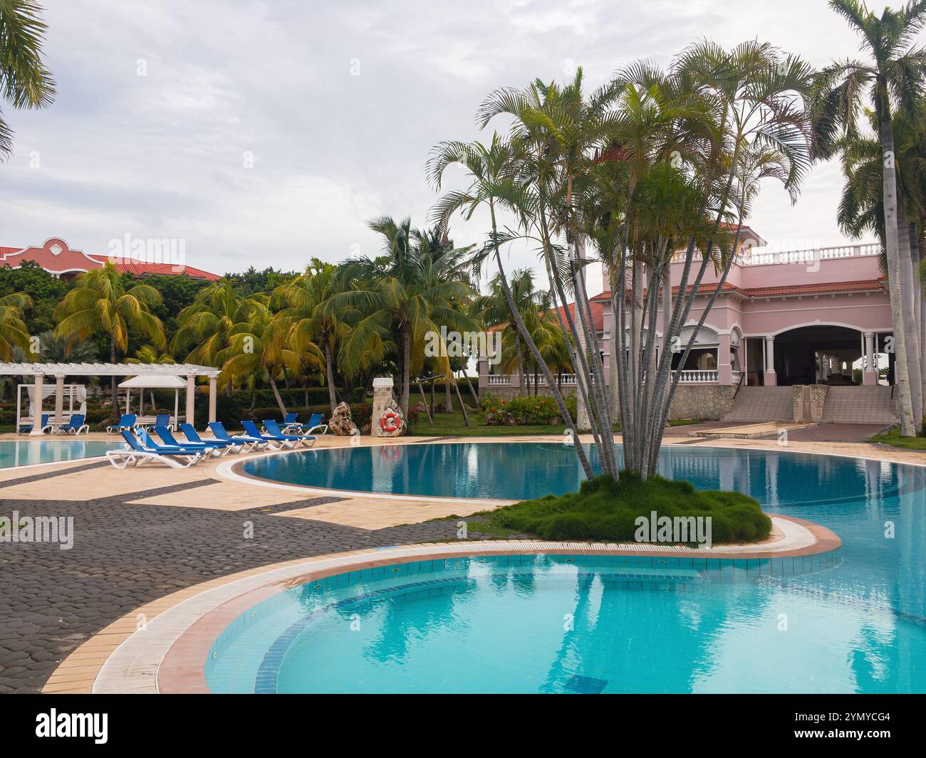 Swimming pool with blue water and palm trees in generic vacation resort ...