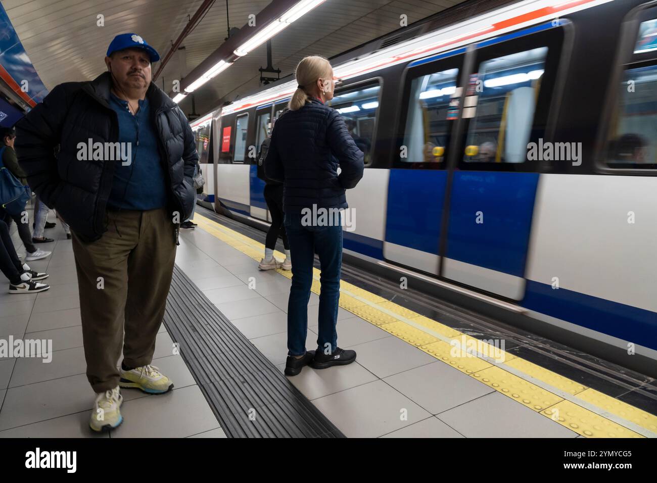 Passengers watch a train arrive at the Sol Metro Station in Puerta del ...