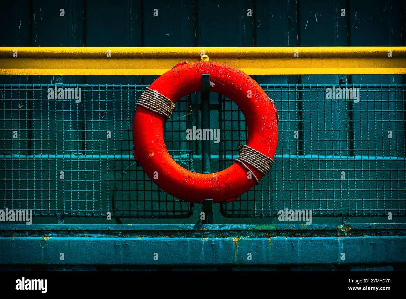 Bright Red Lifebuoy Mounted on a Colorful Rail with Industrial Backdrop ...