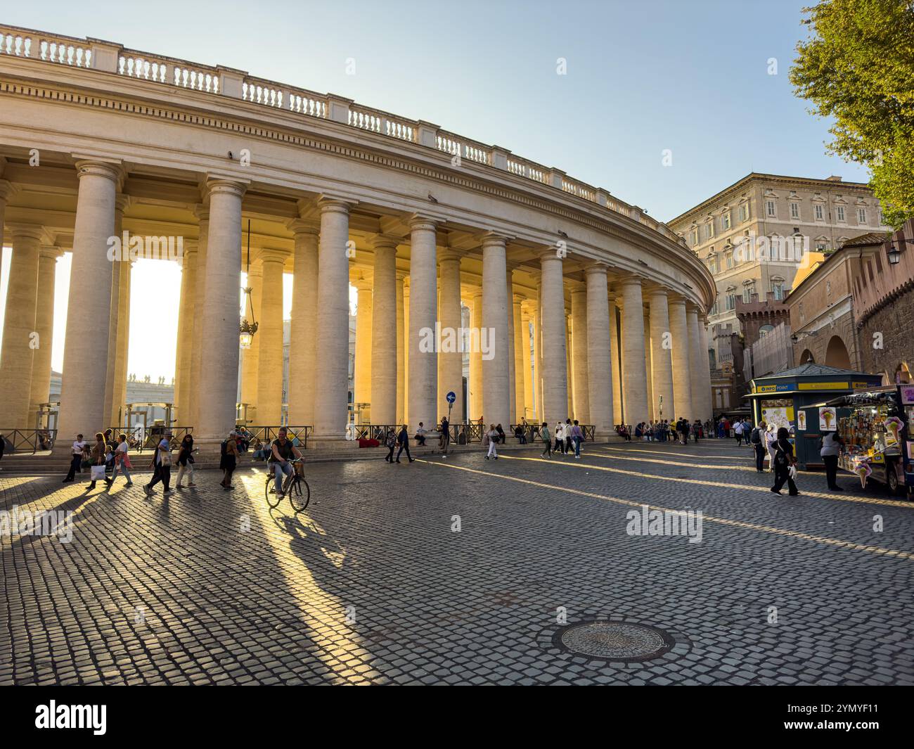 People walk through the colonnade at St. Peter's Basilica Stock Photo ...