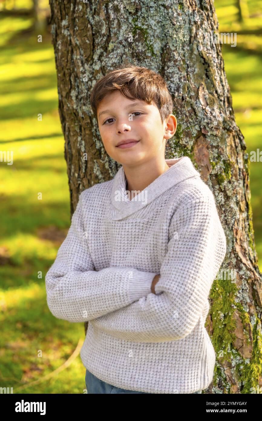 Vertical portrait of a caucasian young boy standing with arms crossed ...