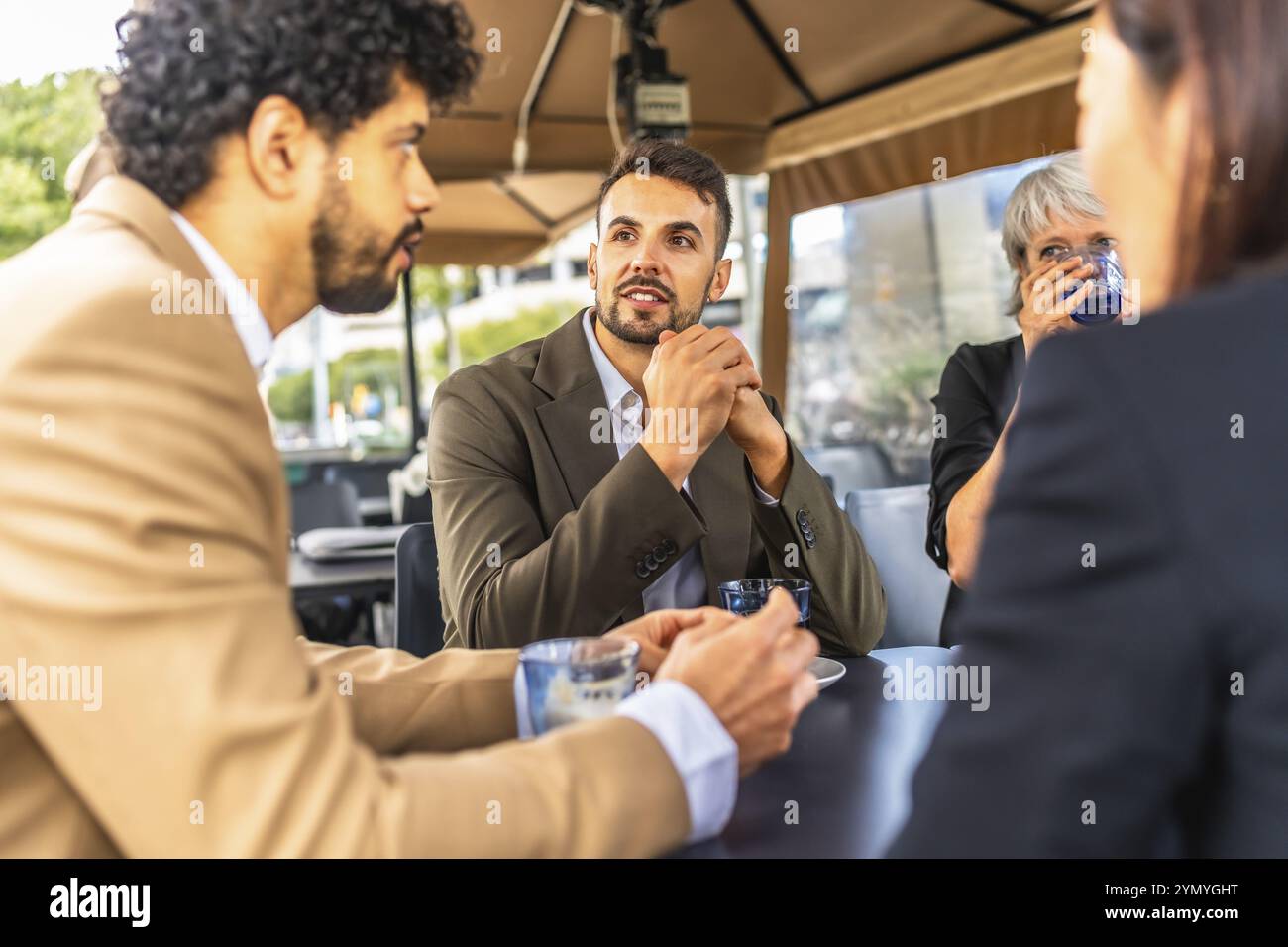 Business coworkers talking while drinking coffee during work break at ...