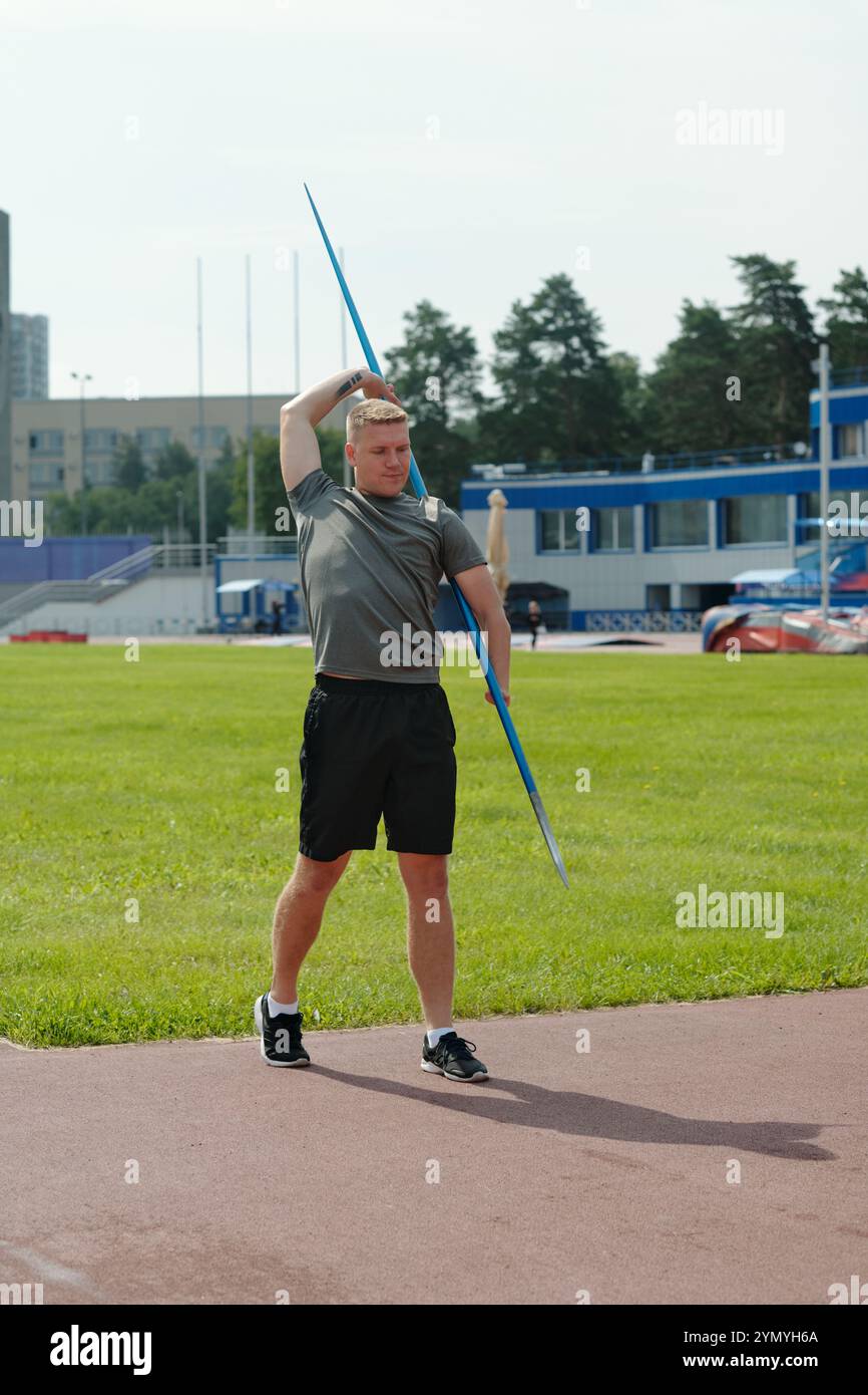 Athlete holding javelin while preparing for throw on sports field ...