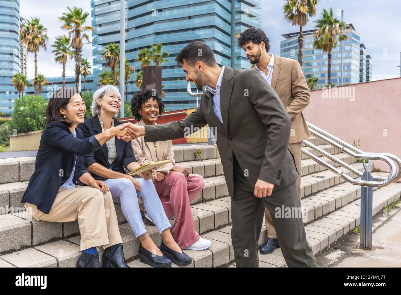 Businessman hand shaking hands with three multi-ethnic businesswoman ...