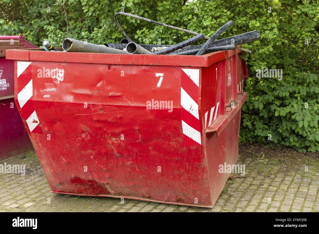 Red container with construction waste Stock Photo - Alamy