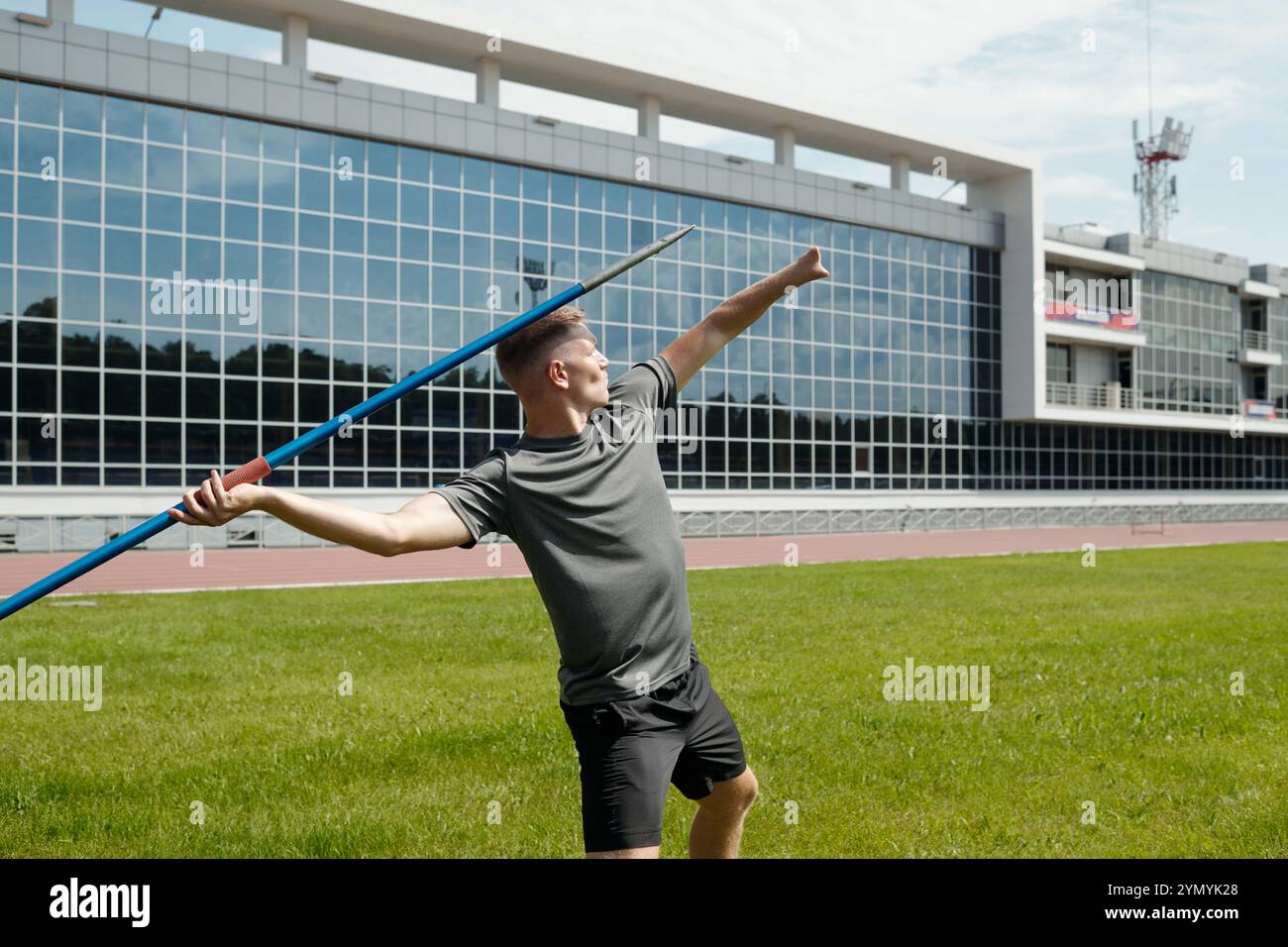 Athlete preparing to throw javelin on field near stadium. Javelin ...