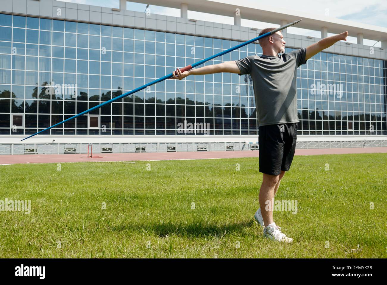 Athlete performing javelin throw on sports field, wearing sportswear ...