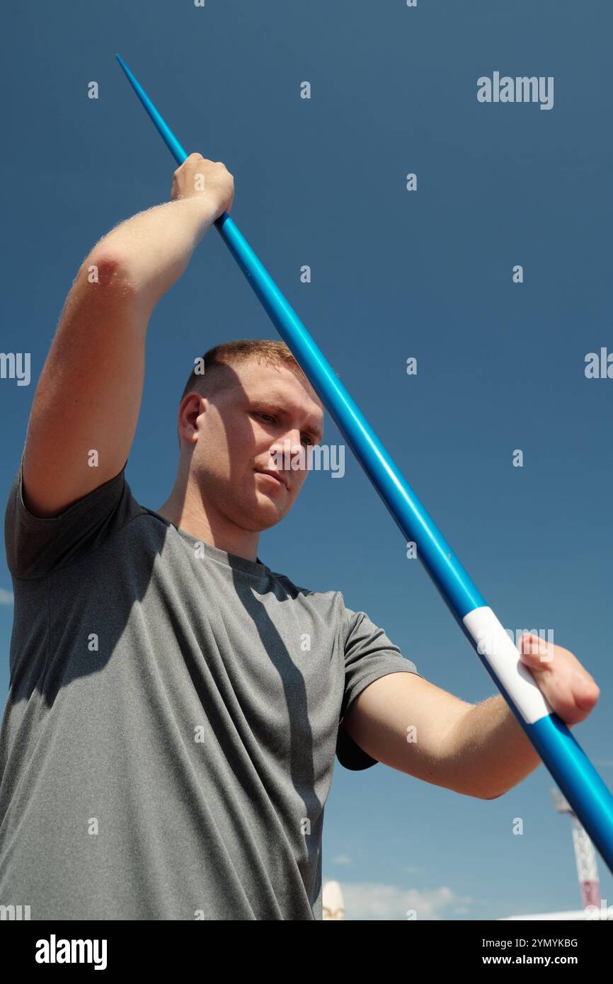 Athlete holding javelin while preparing for throw under clear sky ...