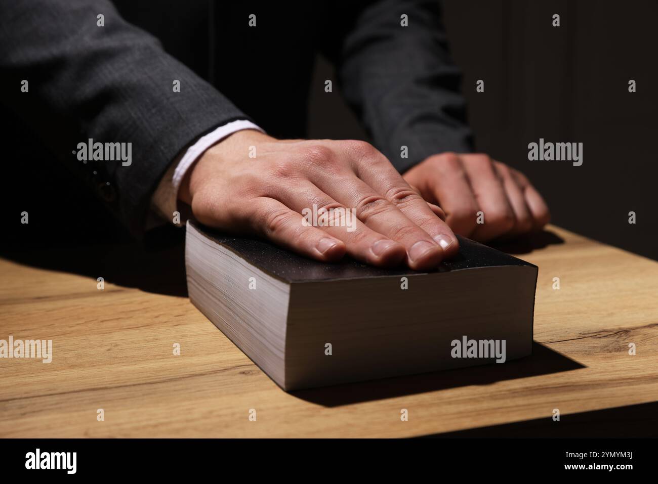 Man taking oath with his hand on Bible at wooden table, closeup Stock ...