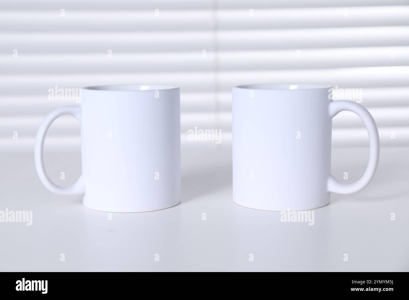 Blank ceramic mugs on white table. Mockup for design Stock Photo - Alamy