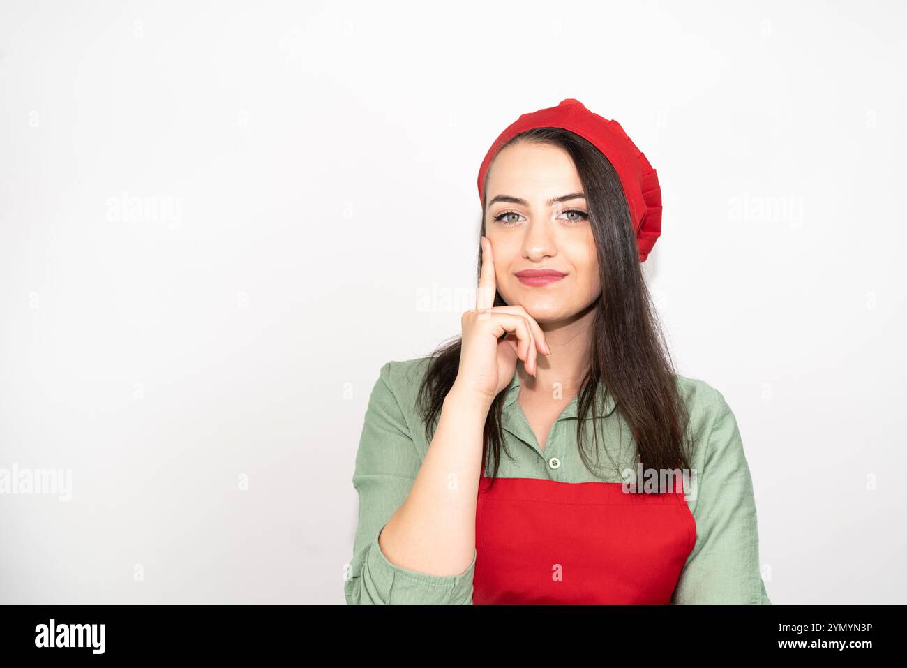 Portrait of young woman chef wearing red apron isolated white color ...
