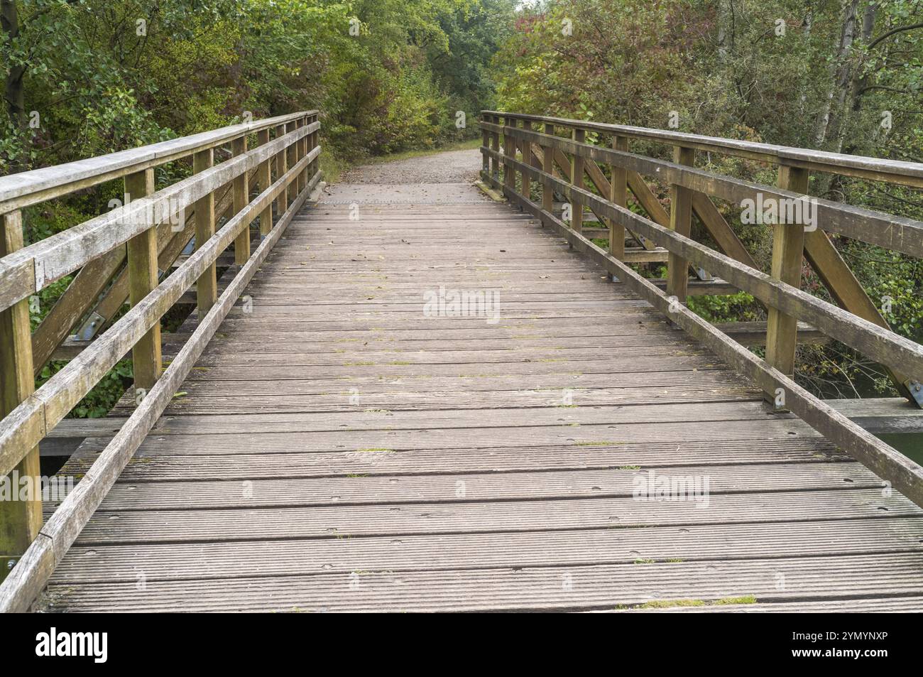 Wide wooden bridge with railing over river Stock Photo - Alamy