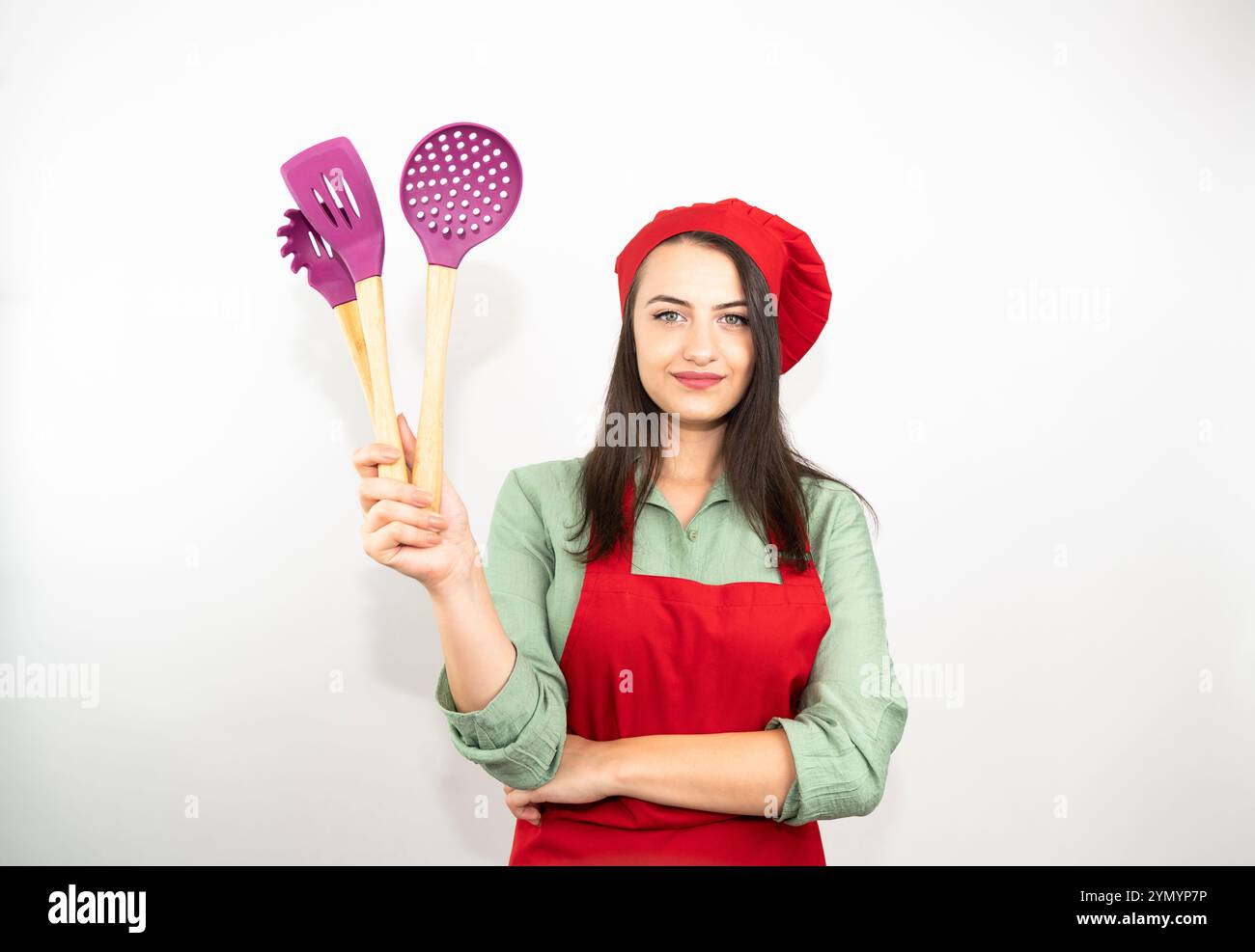Portrait of young woman chef wearing red apron isolated white color ...