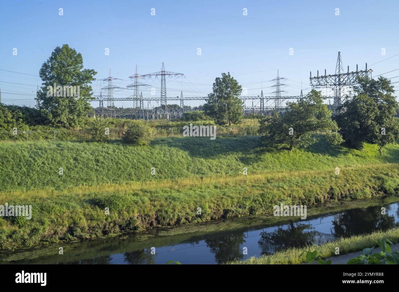 High-voltage pylons with sewer in the countryside Stock Photo - Alamy
