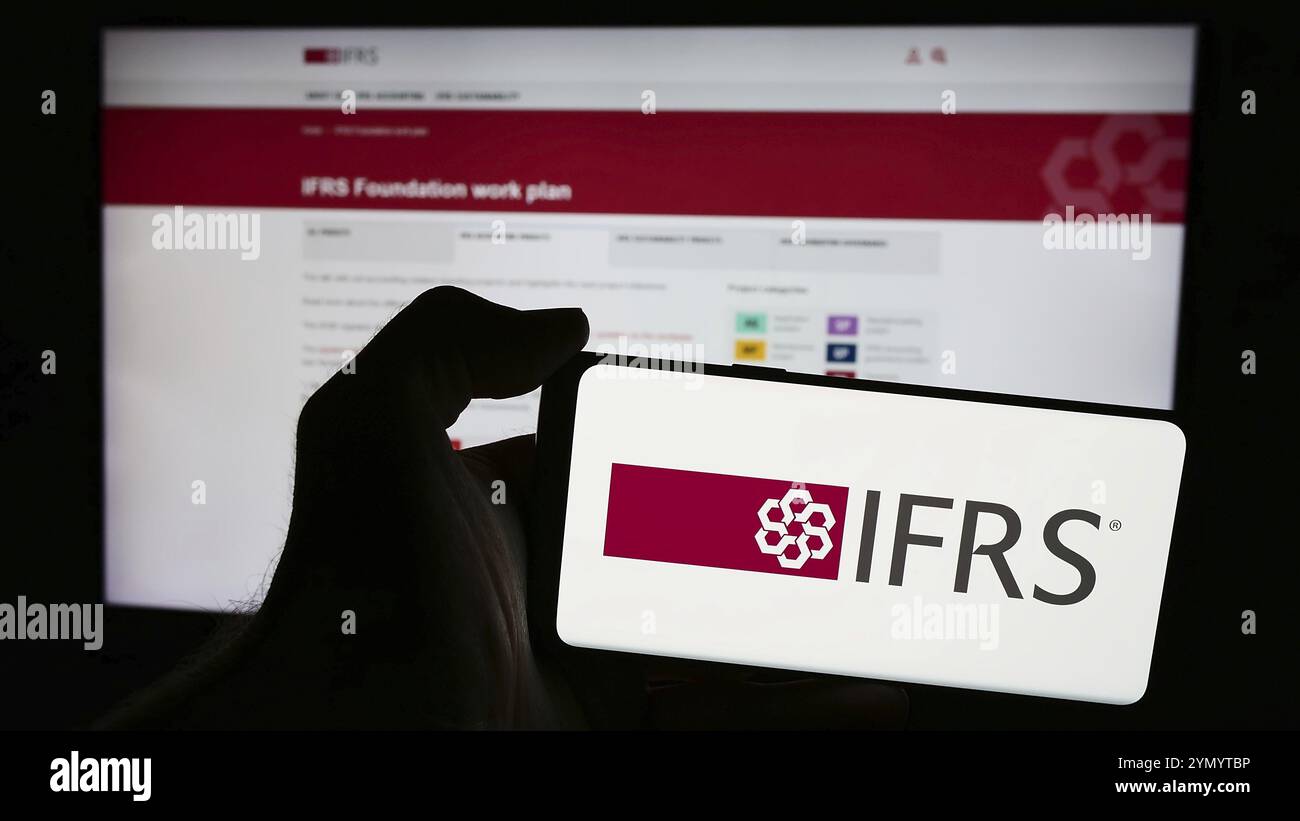 Stuttgart, Germany, 06-26-2024: Person holding mobile phone with logo of International Financial ...