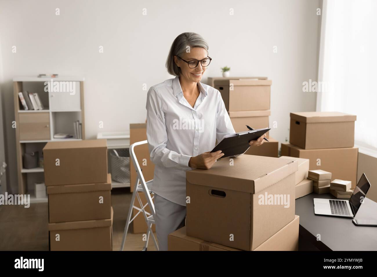 Positive delivery service office employee counting parcels Stock Photo ...