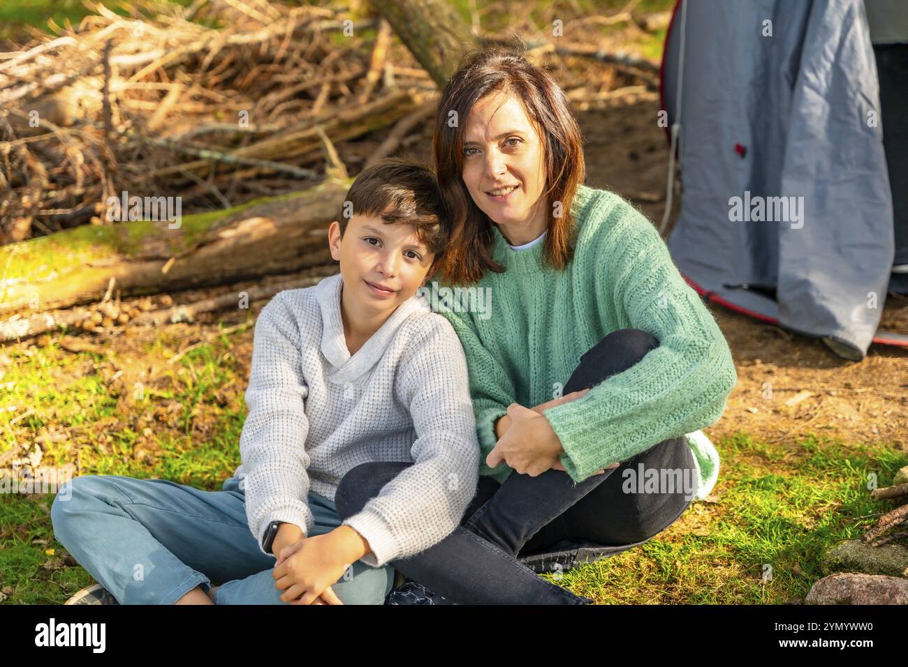 Caucasian mother and son smiling at camera sunbathing enjoying nature ...