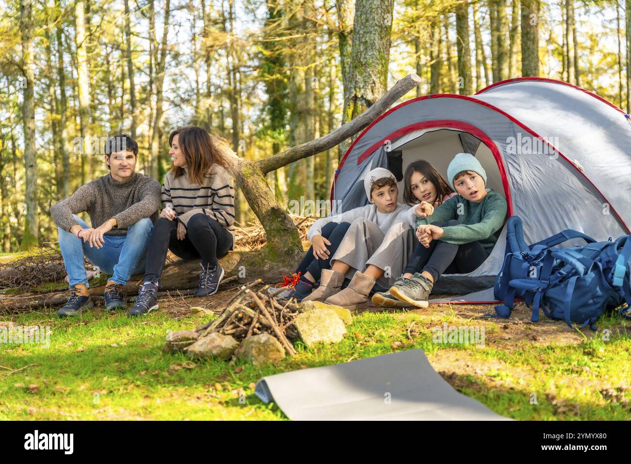 Caucasian family with three children enjoying day camping in the forest ...