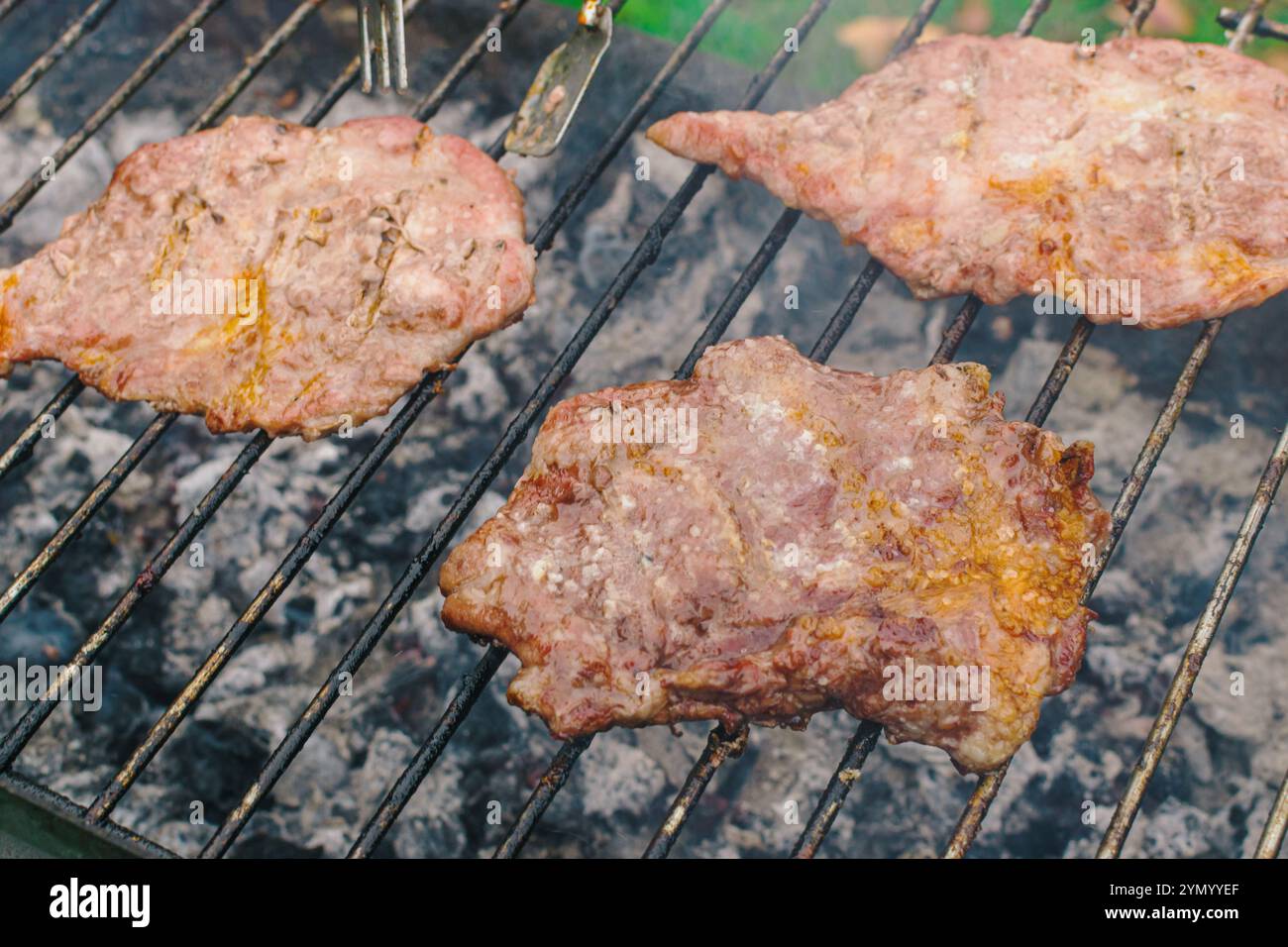 Fresh juicy pork secreto fillet and condiments roasting in a charcoal ...