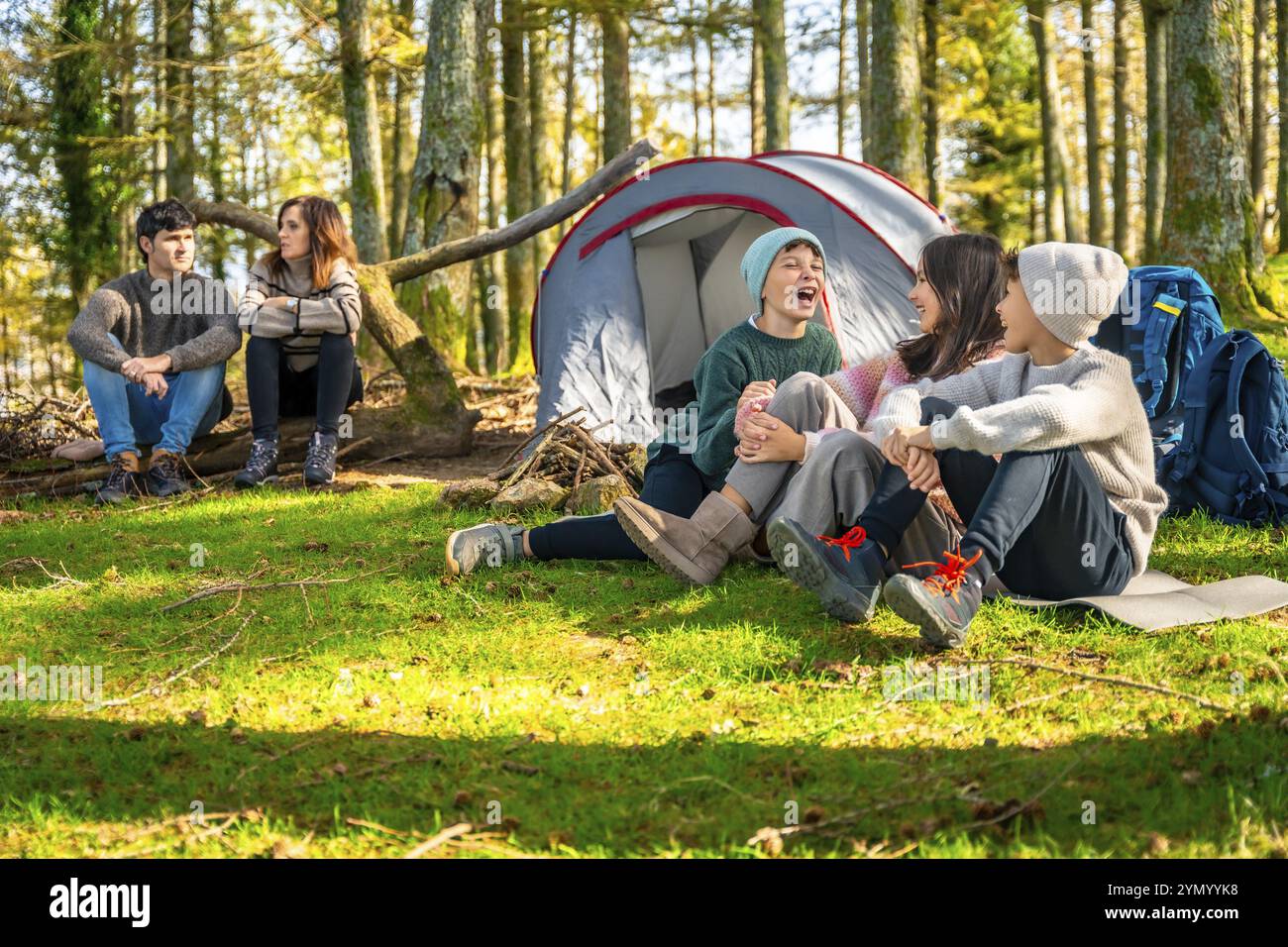 Caucasian family with three children sitting enjoying nature during a ...