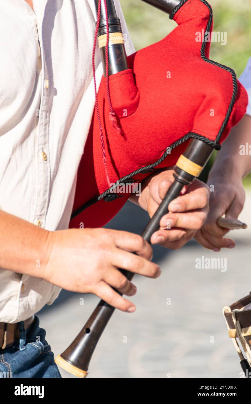 hands of a bagpipe player playing a traditional red bagpipe from ...