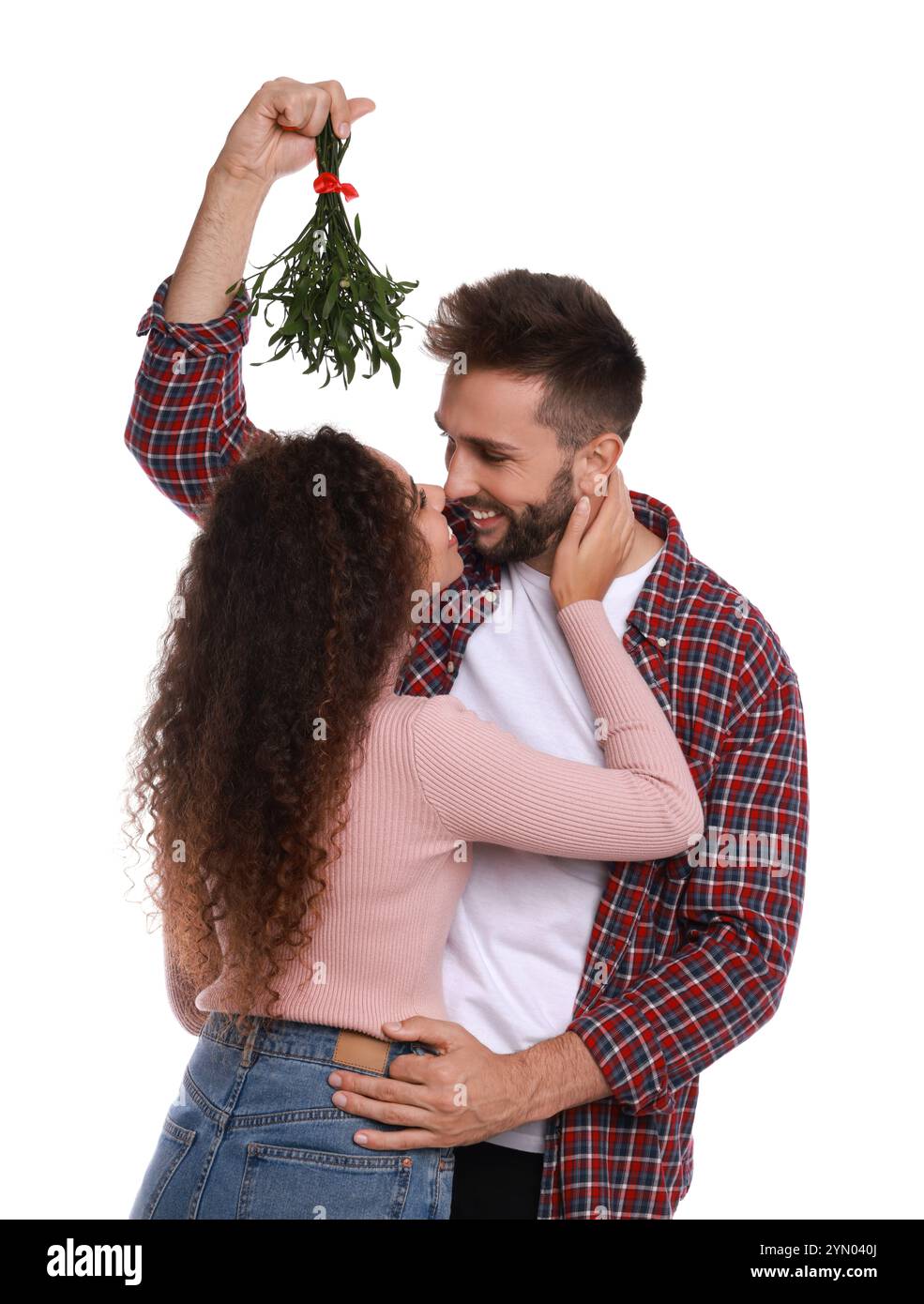 Lovely couple under mistletoe bunch on white background Stock Photo - Alamy