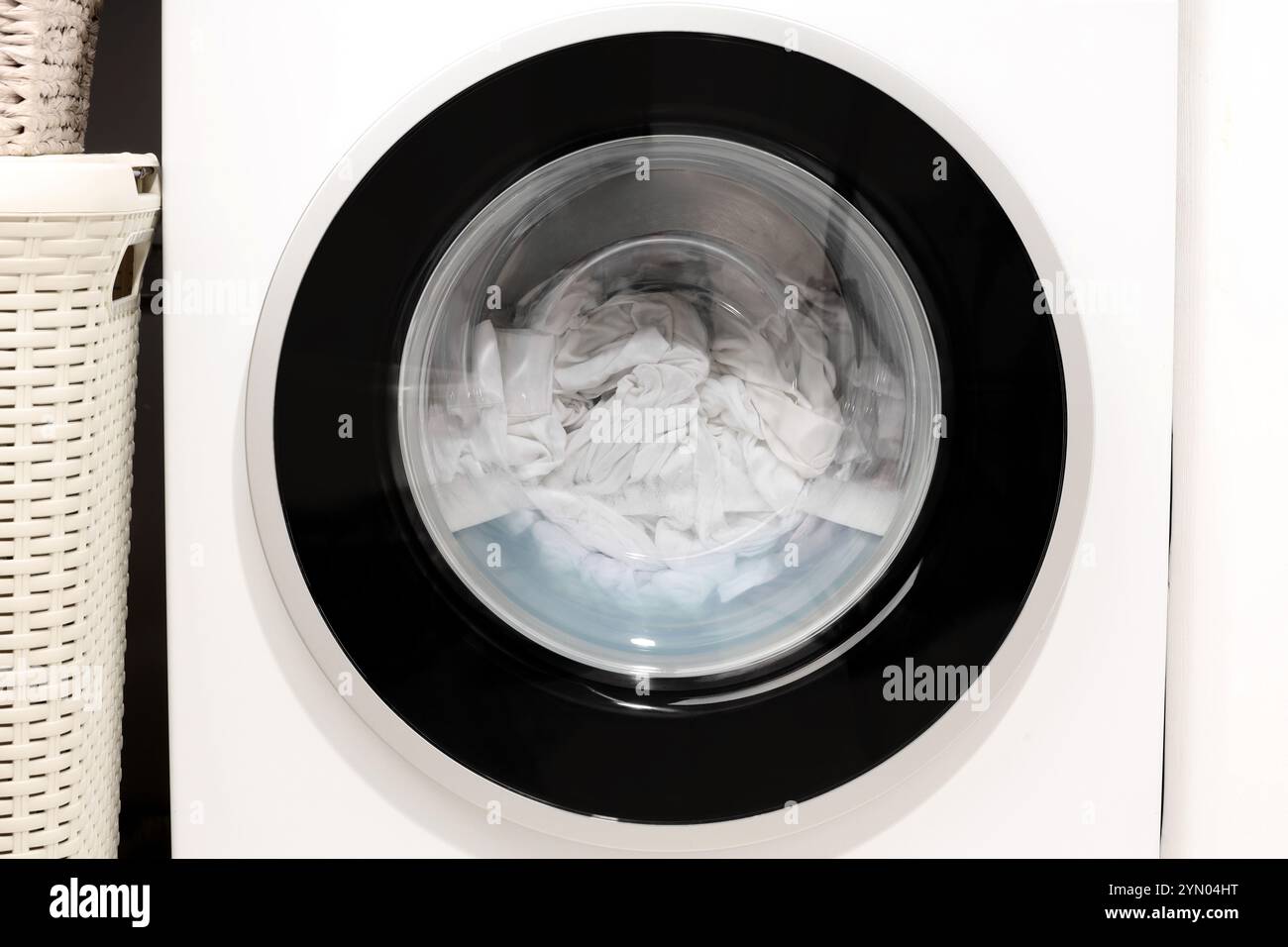Washing machine with clothes as background, closeup Stock Photo - Alamy