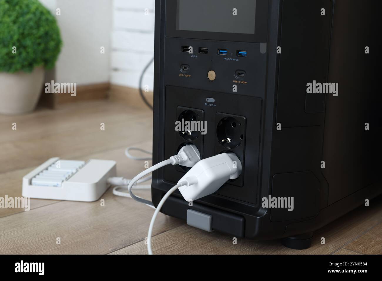 Modern portable power station with attached device indoors, closeup ...