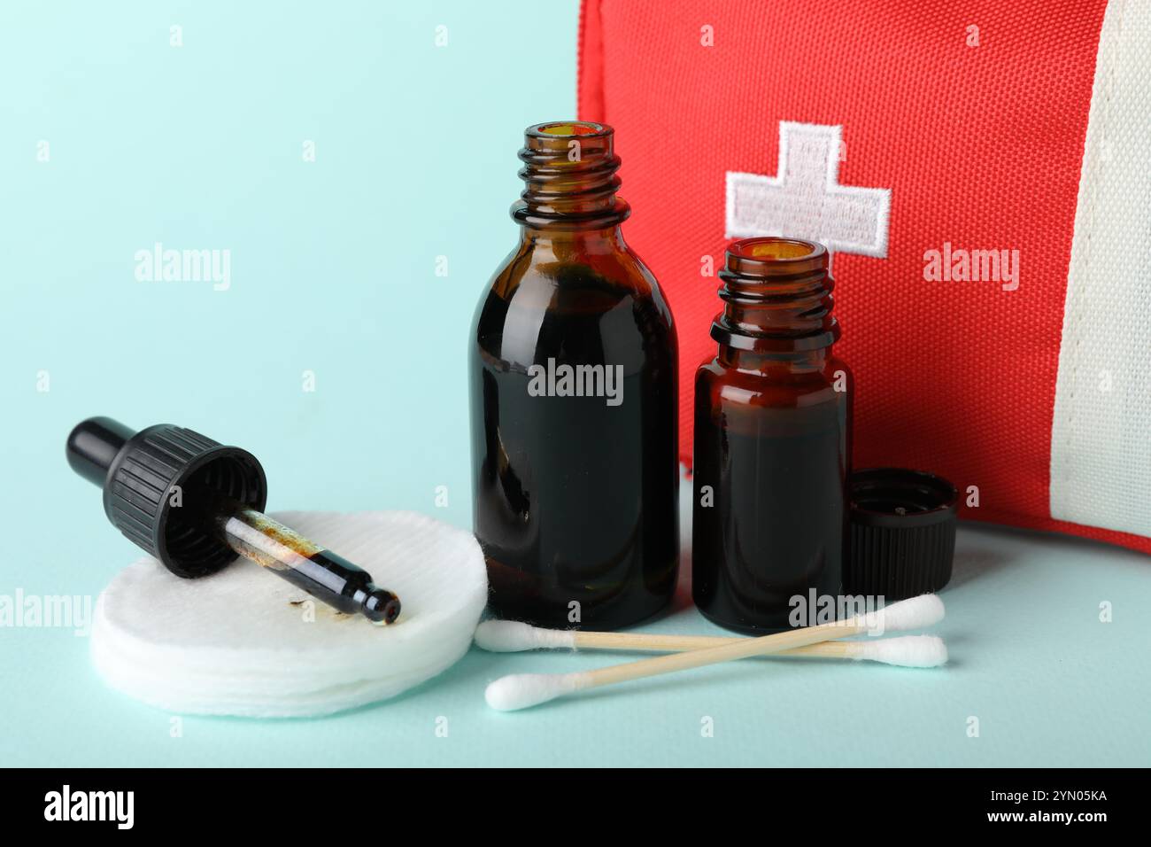 Topical iodine and other first aid kit components on light blue ...