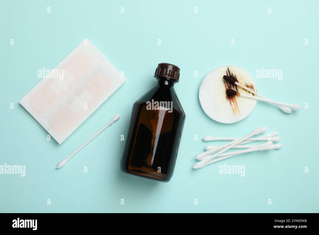 Topical iodine and other first aid kit components on light blue ...