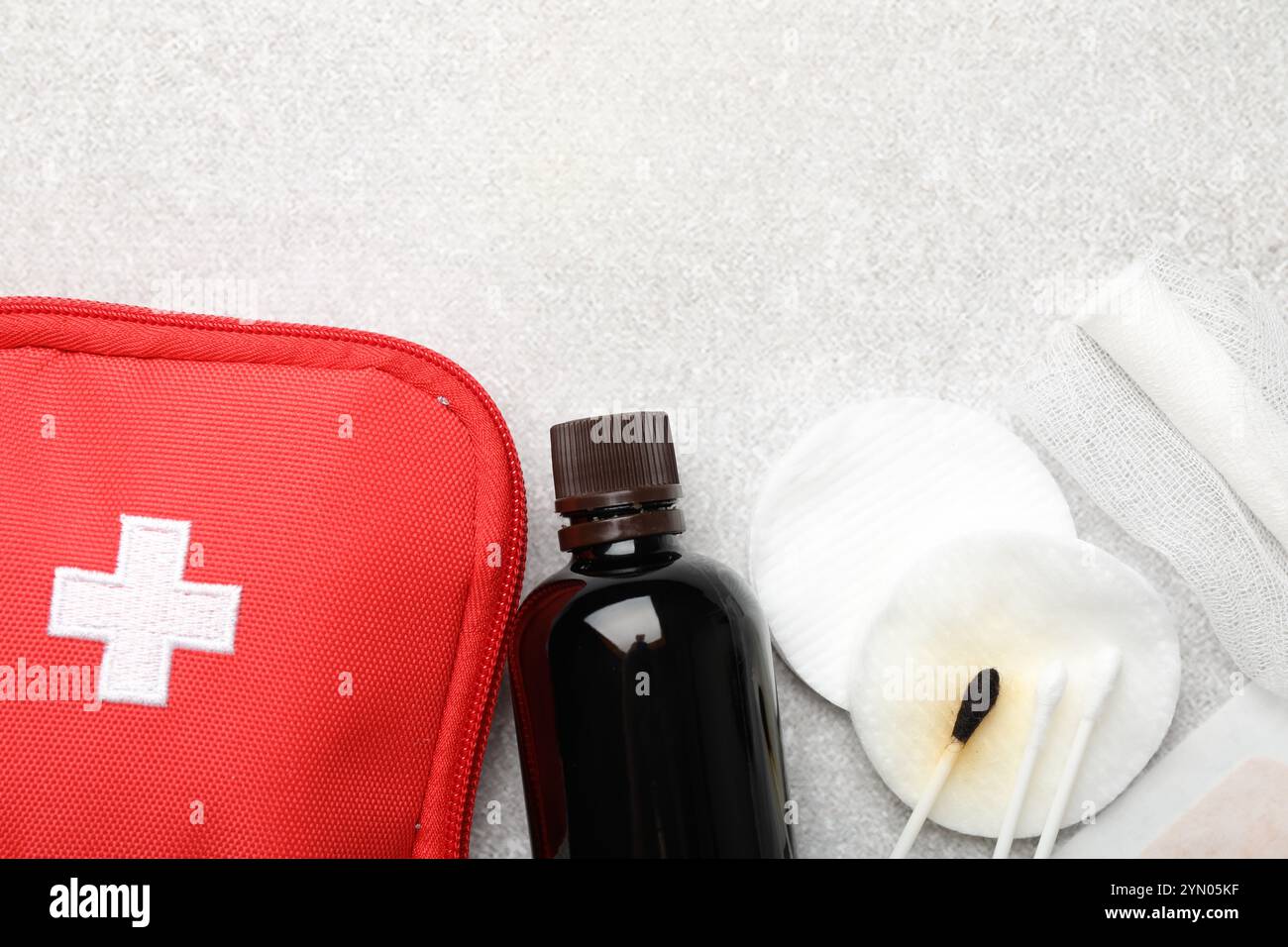 Topical iodine and other first aid kit components on light background ...