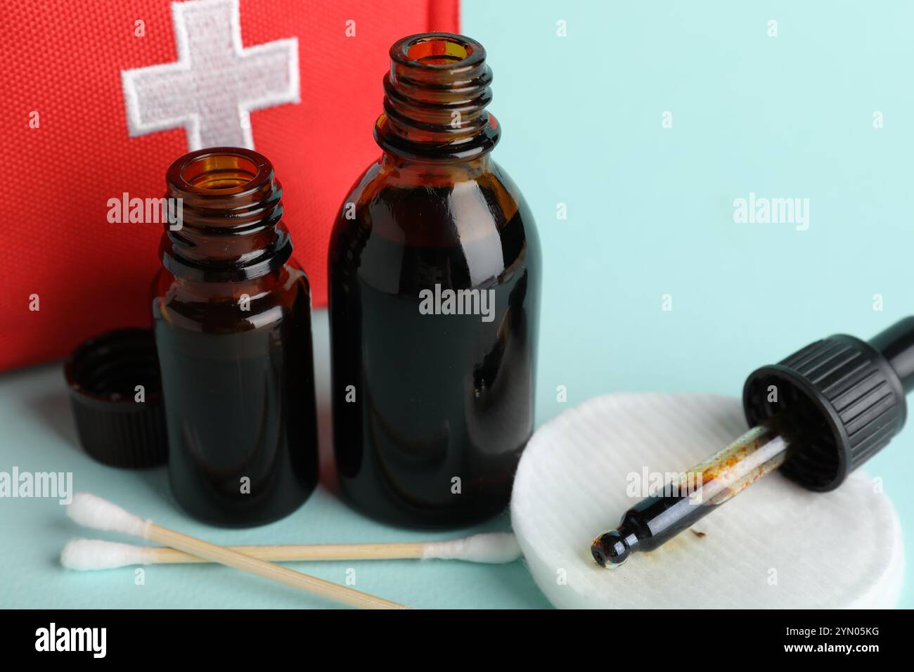 Topical iodine and other first aid kit components on light blue ...