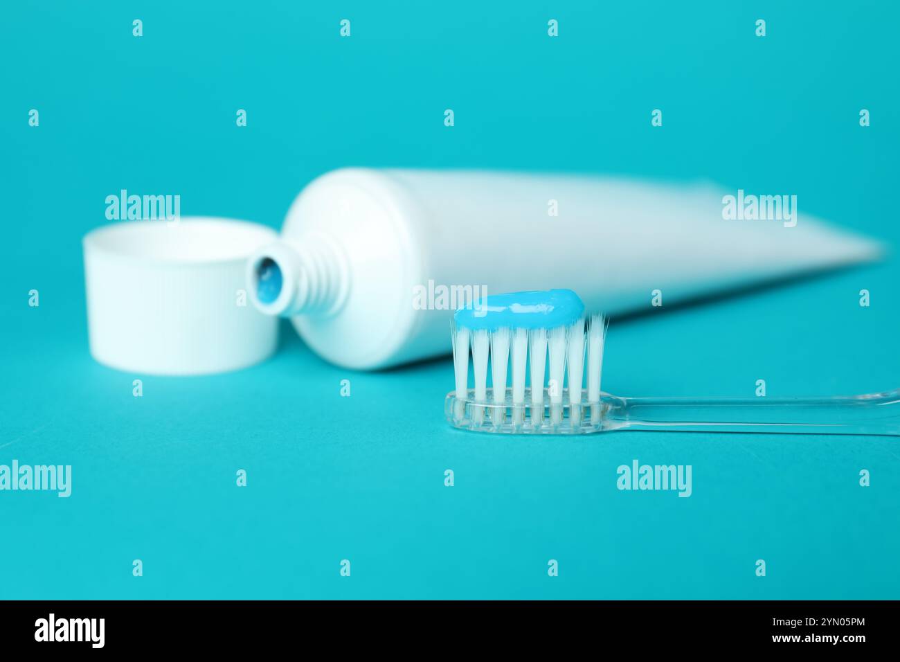 Toothbrush with toothpaste and tube on light blue background Stock ...