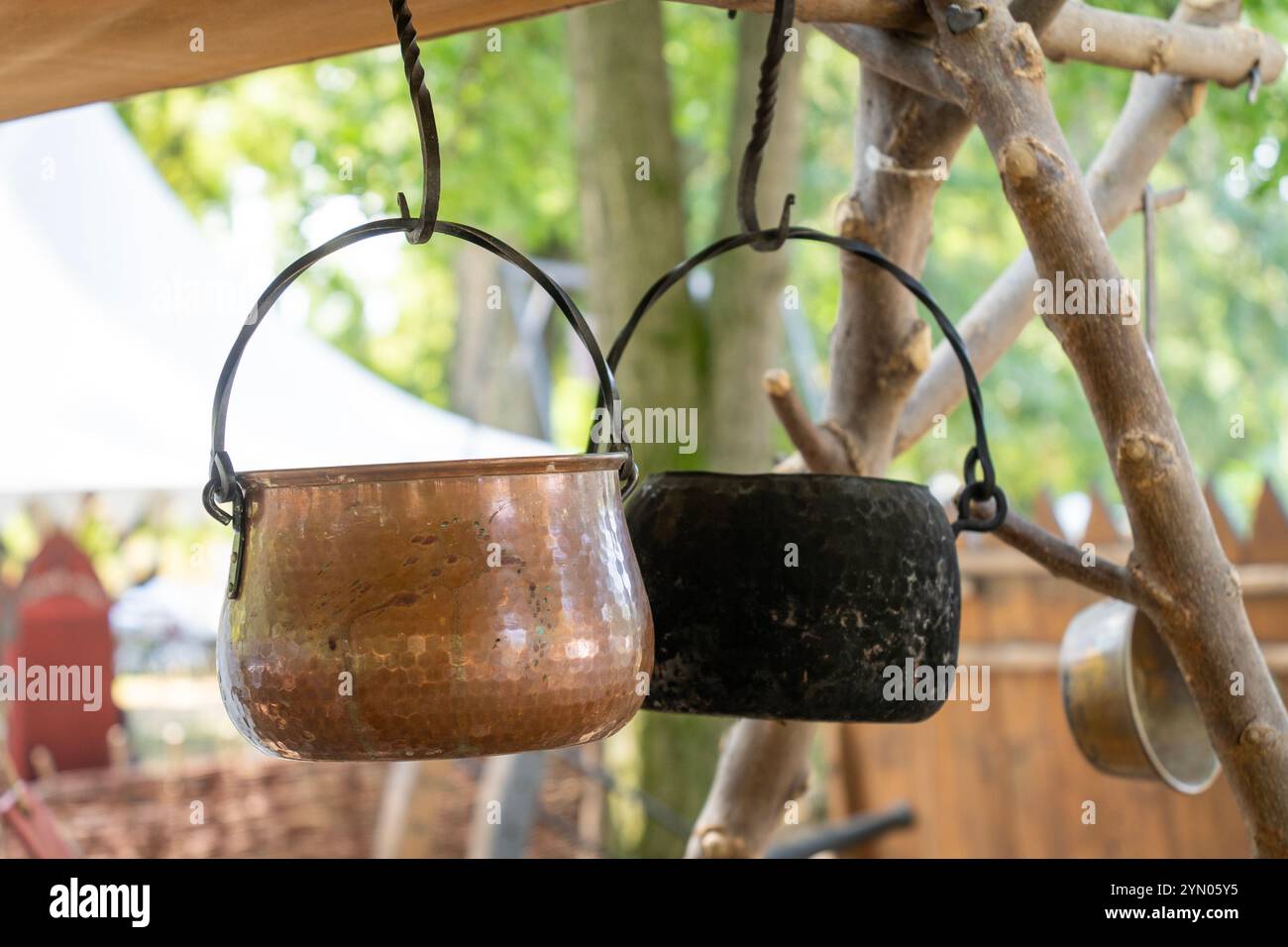 Hanging old metal cooking pots outdoors Stock Photo - Alamy