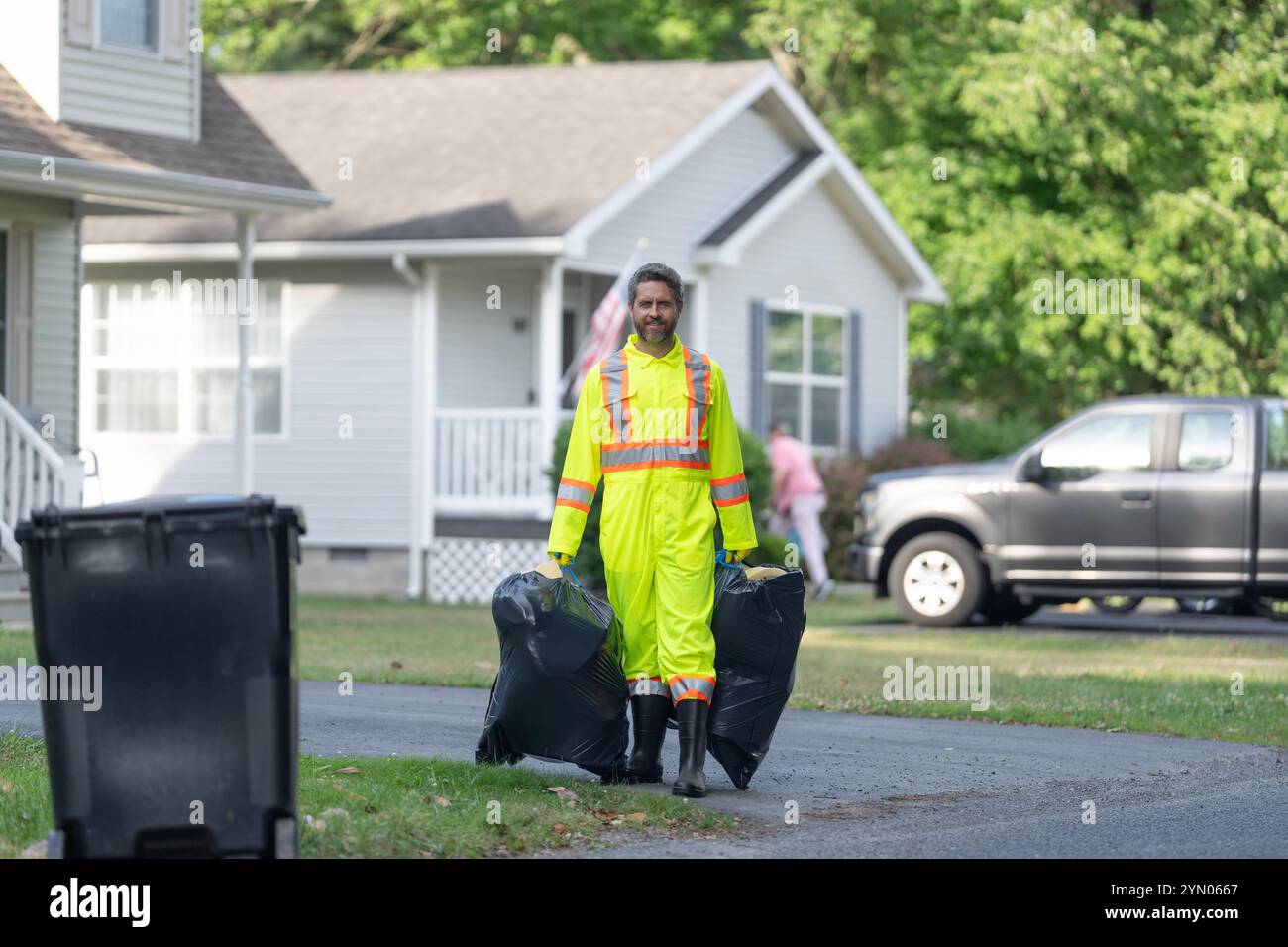 Pollution and recycling. Man putting garbage bag in a trash bin ...