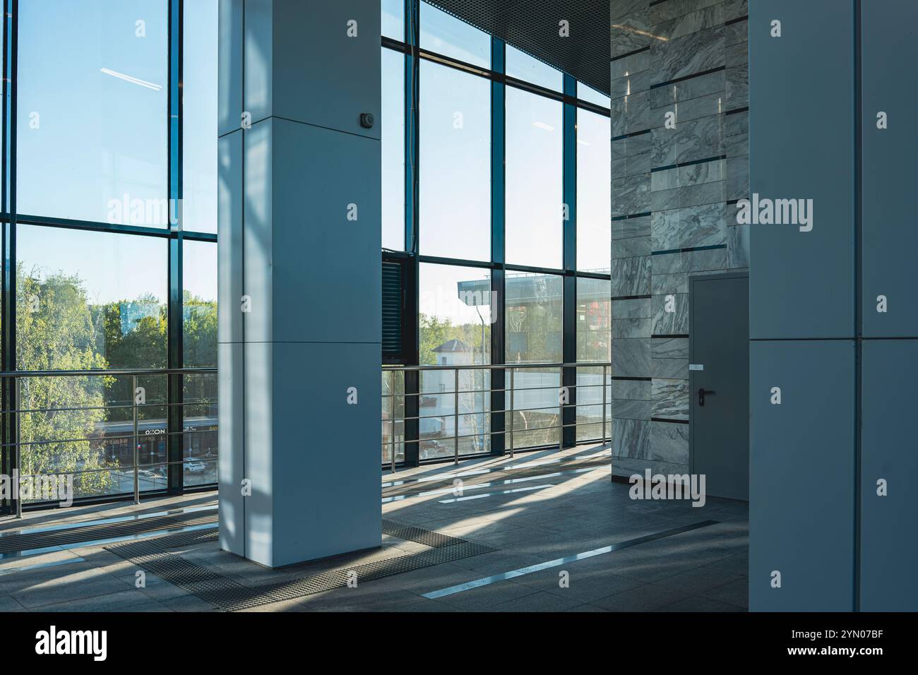 A modern building interior featuring large glass windows with natural ...