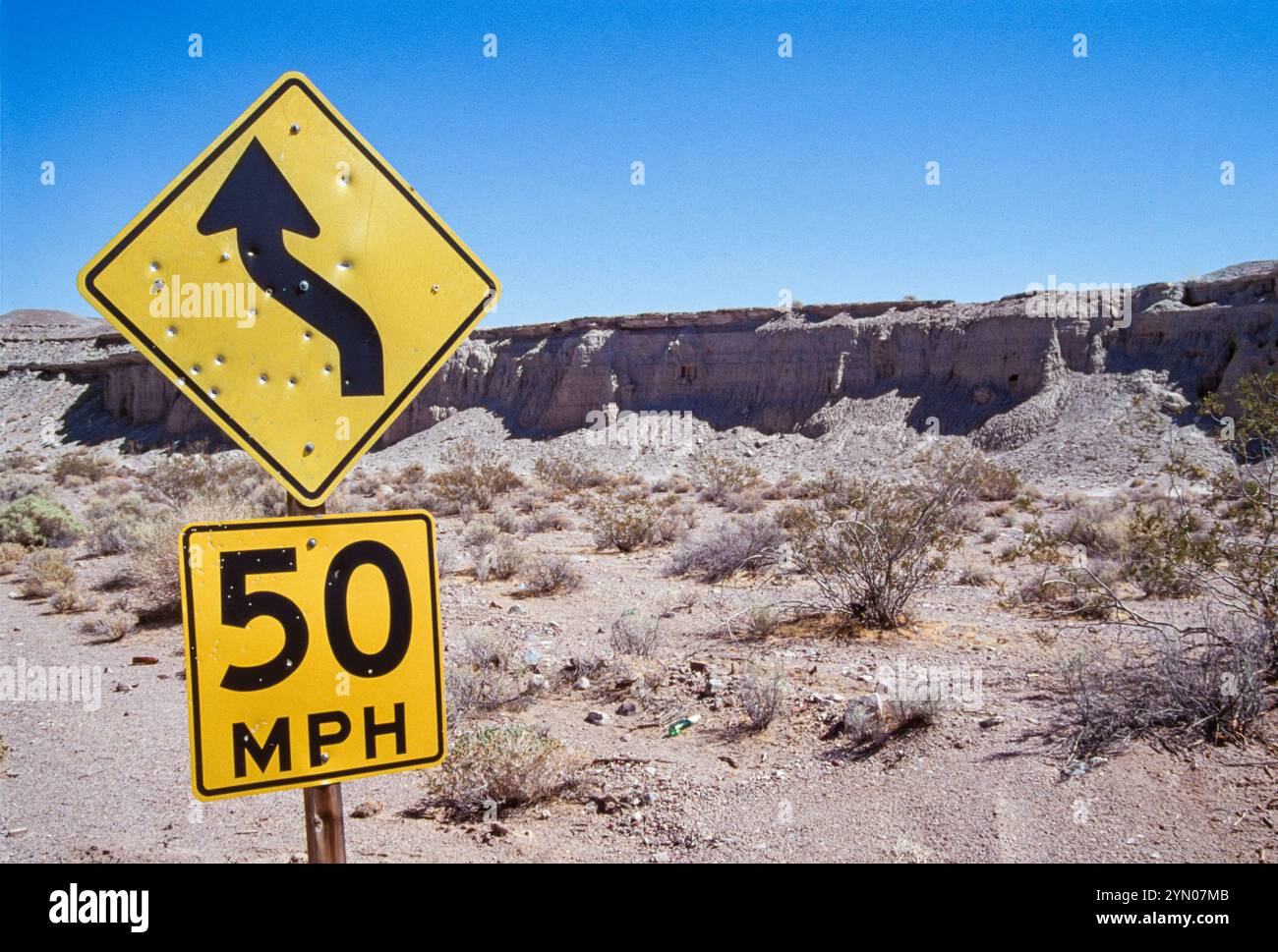 Speed limit and curved road ahead signs in Death Valley, California ...
