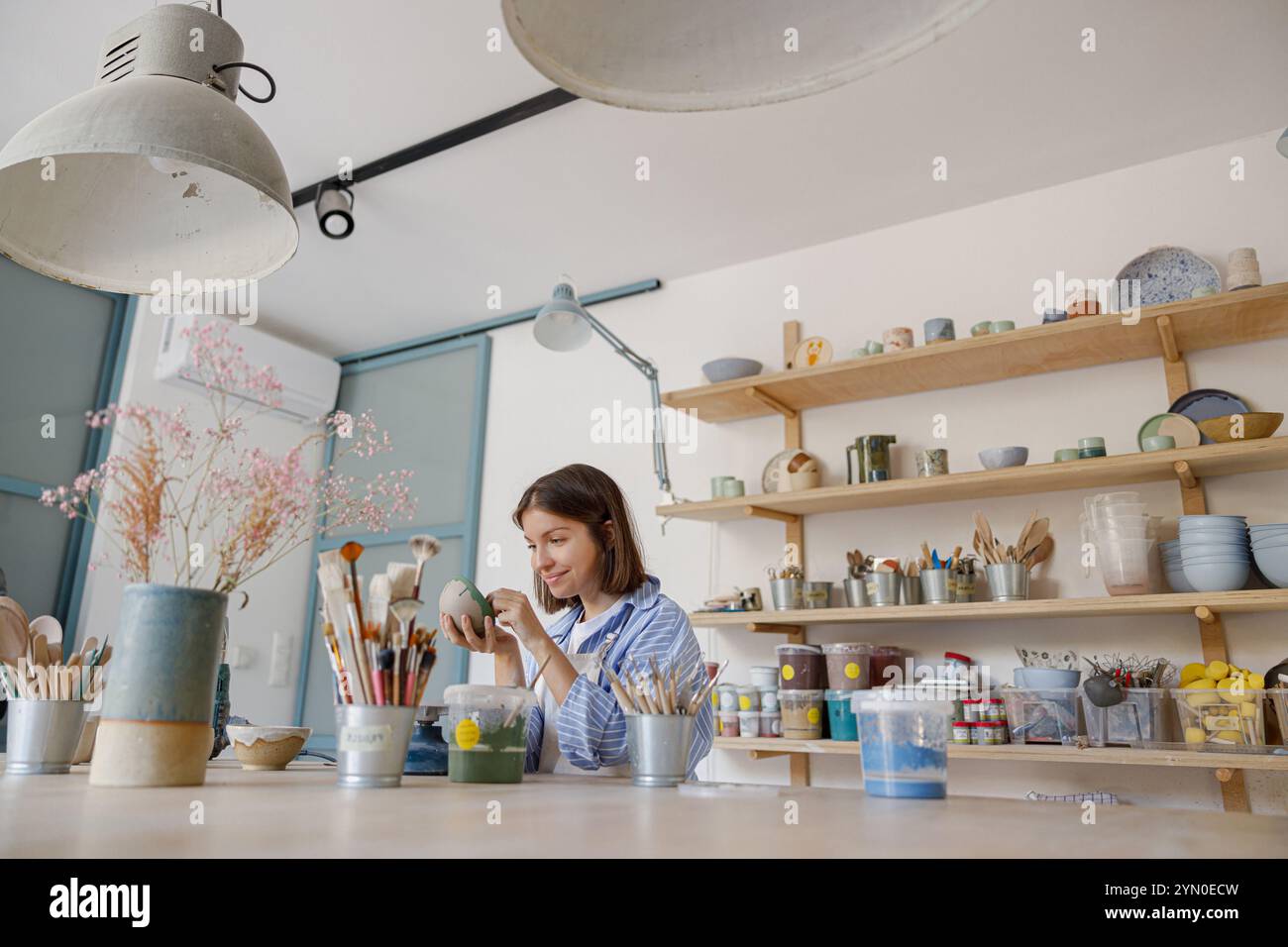 Creative and talented Artist working in a Bright Clay Studio filled ...