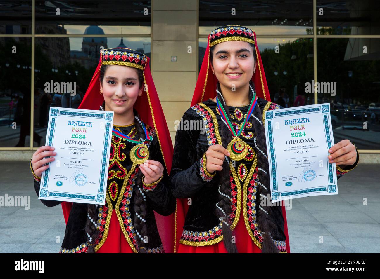 Two cute Azerbaijani girls in traditional attire showing their silver ...