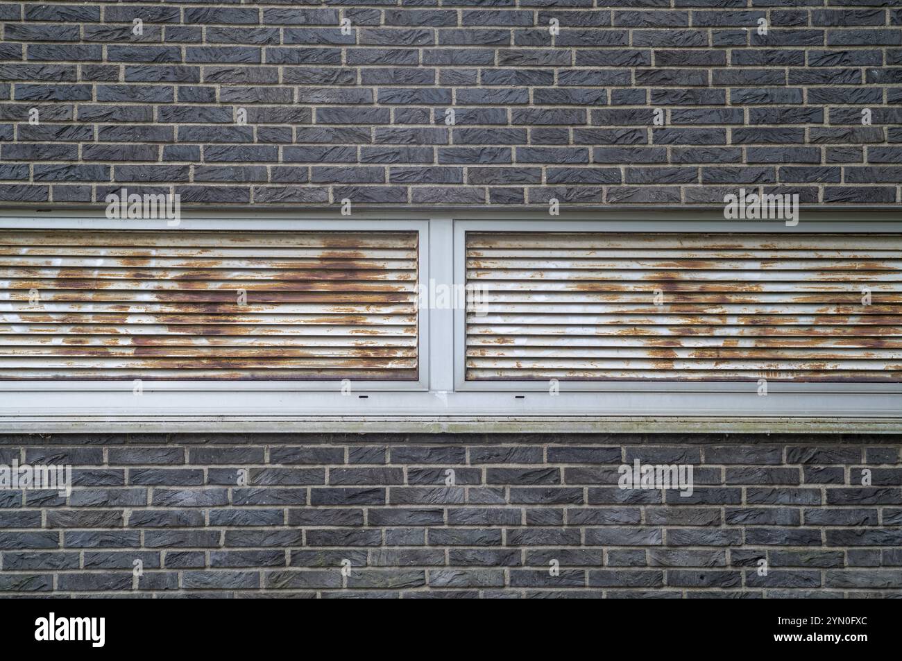 Brick wall with windows and rusted blinds Stock Photo - Alamy